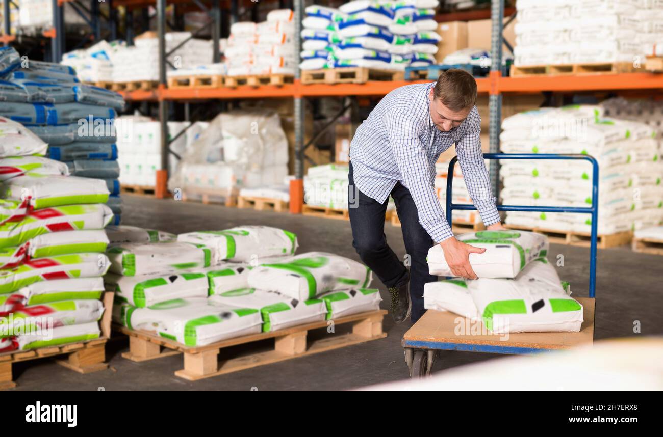 Man choosing compost soil in plastic bags in hypermarket Stock Photo ...