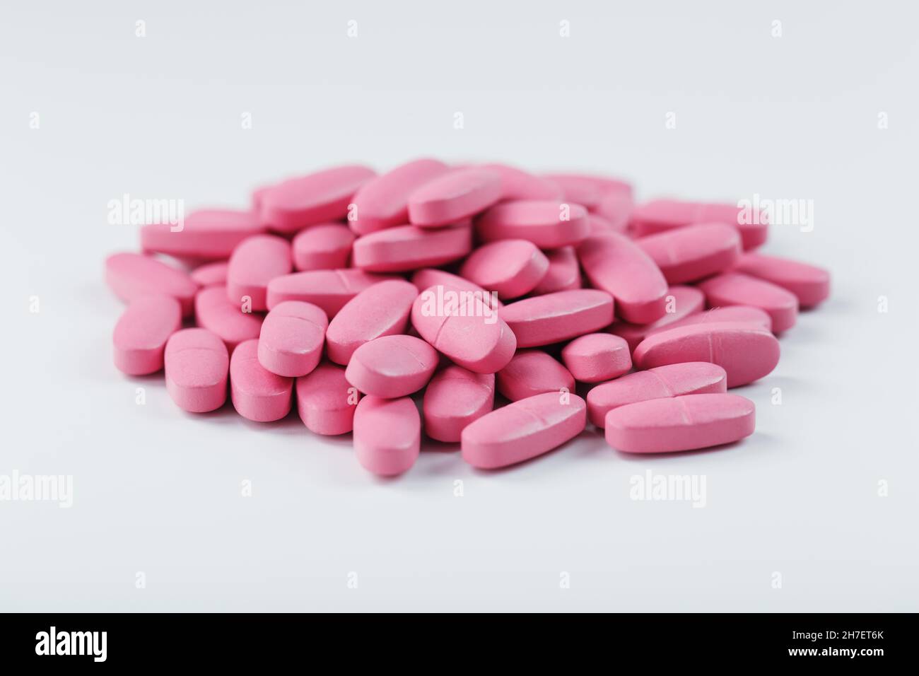 Pink vitamin pills for women on a white background. Multivitamins for ...