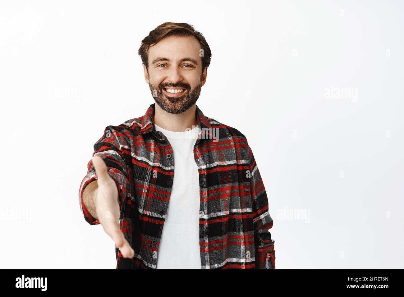 Portrait of friendly man extending his hand for handshake, greeting you ...