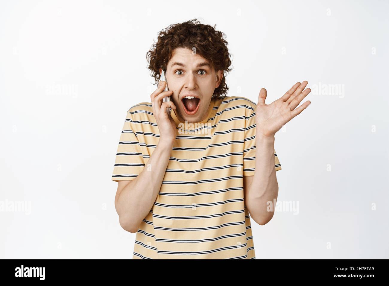 Image of young man answer phone call and scream surprised, receive ...