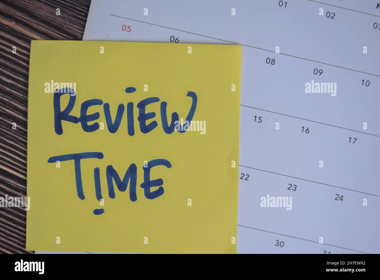 Review Time write on sticky notes and Calendar isolated on Wooden Table ...