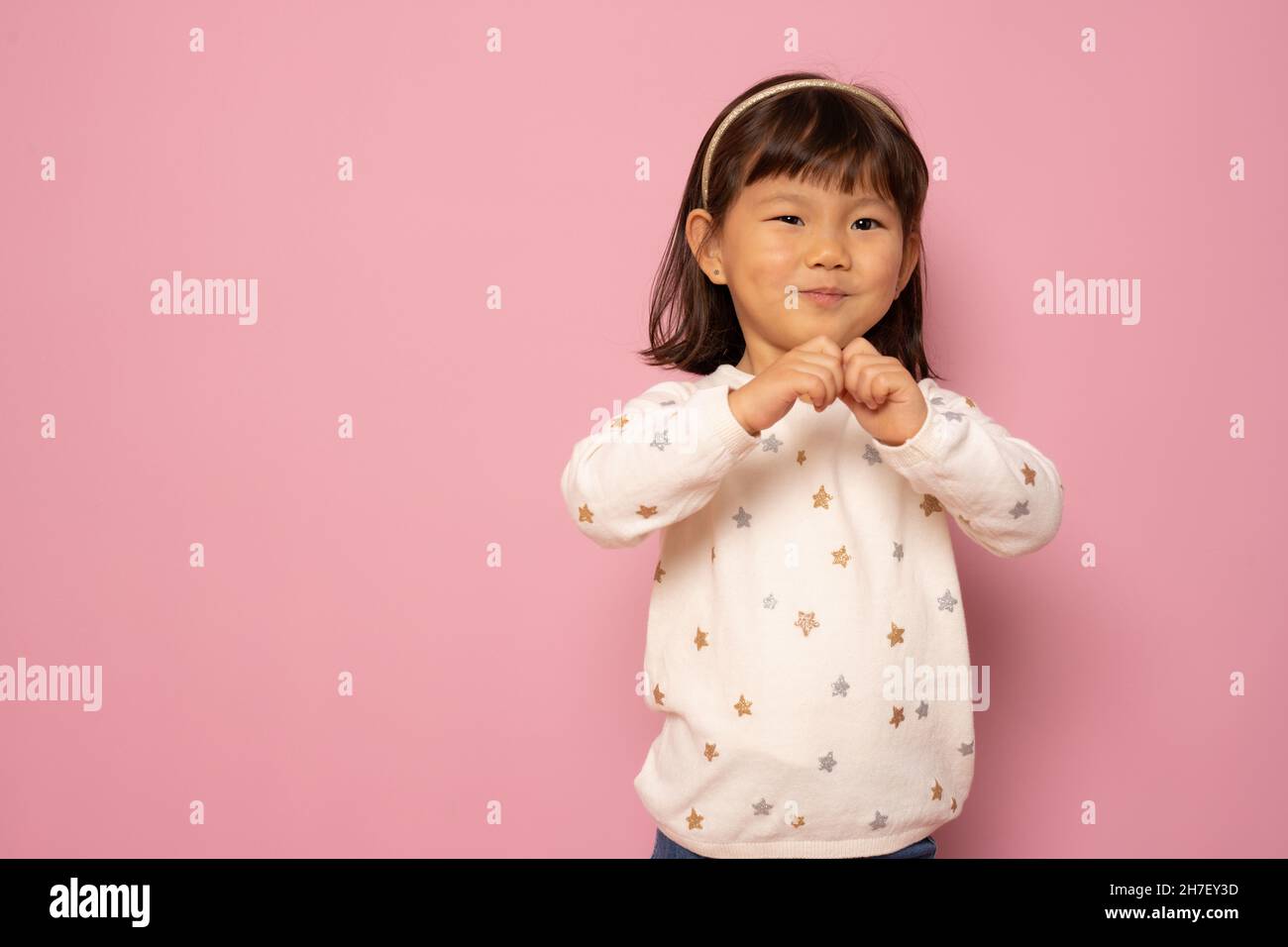 Portrait of beautiful little asian girl isolated over pink background ...