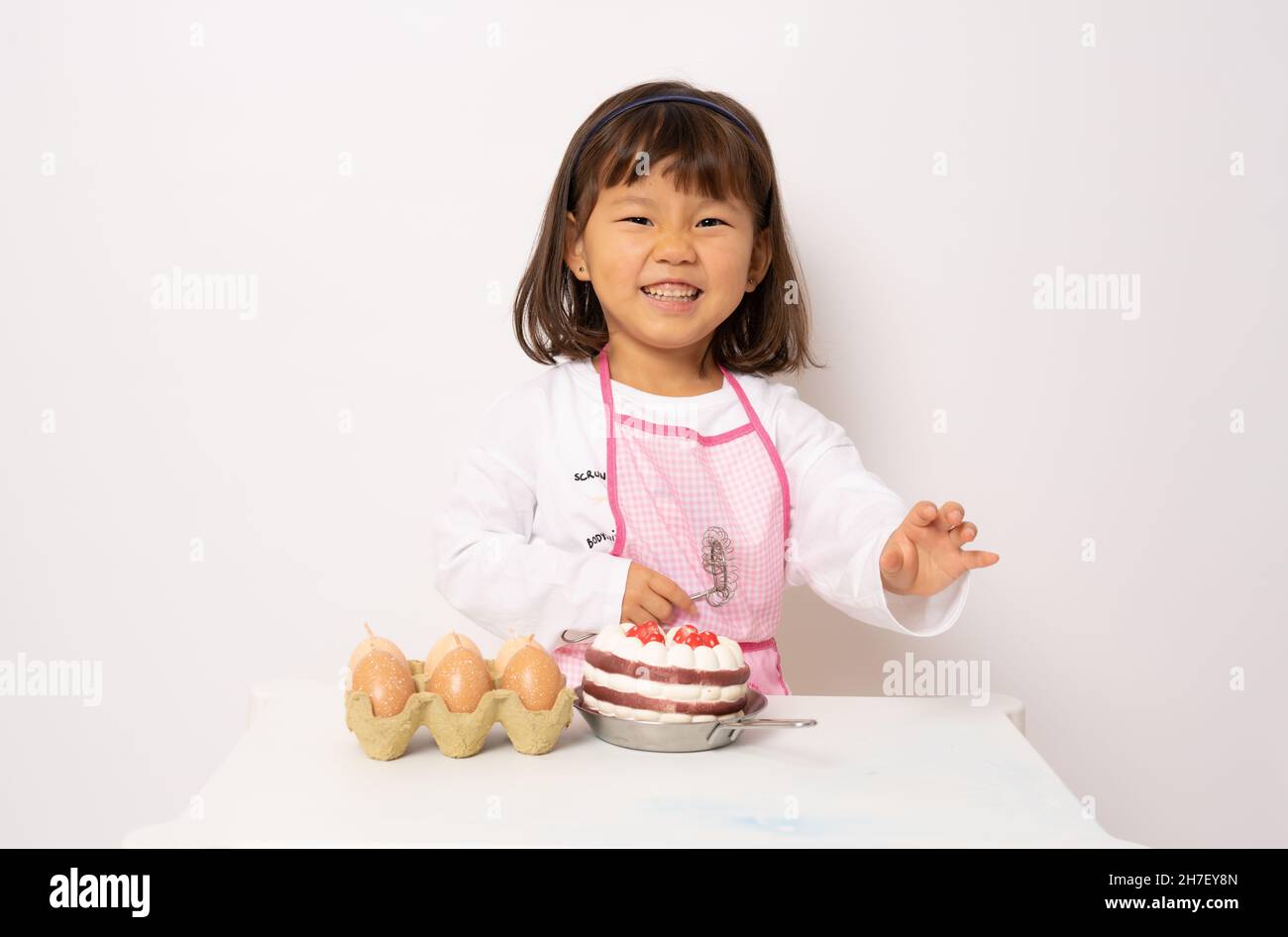 Beautiful little asian girl cooking isolate on white background Stock ...