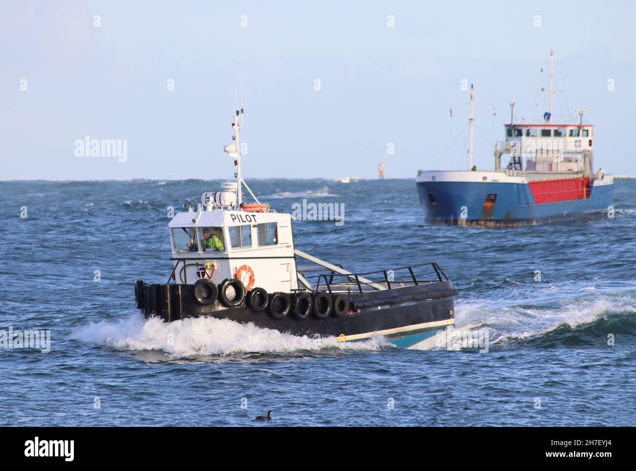 Pilot boat leading ship into harbour Stock Photo - Alamy