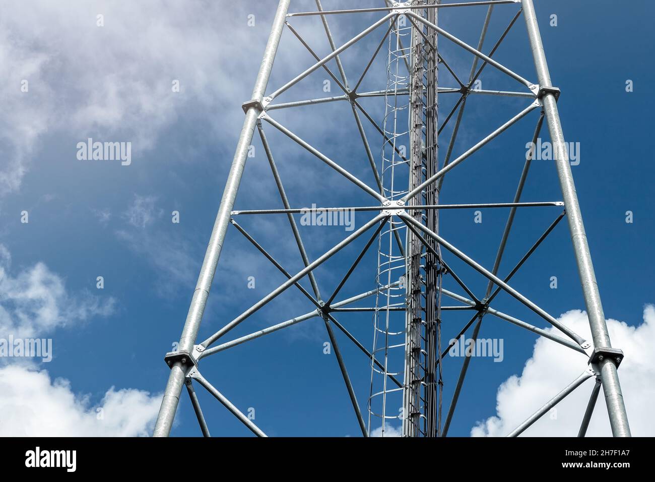Bottom perspective pov of modern metal steel mobile 5g network wireless telecom tower against ...