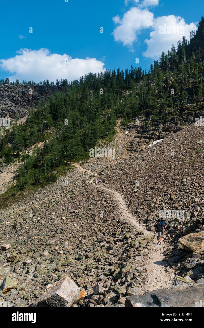 Vertical shot of people walking on a rocky hiking trail Stock Photo - Alamy