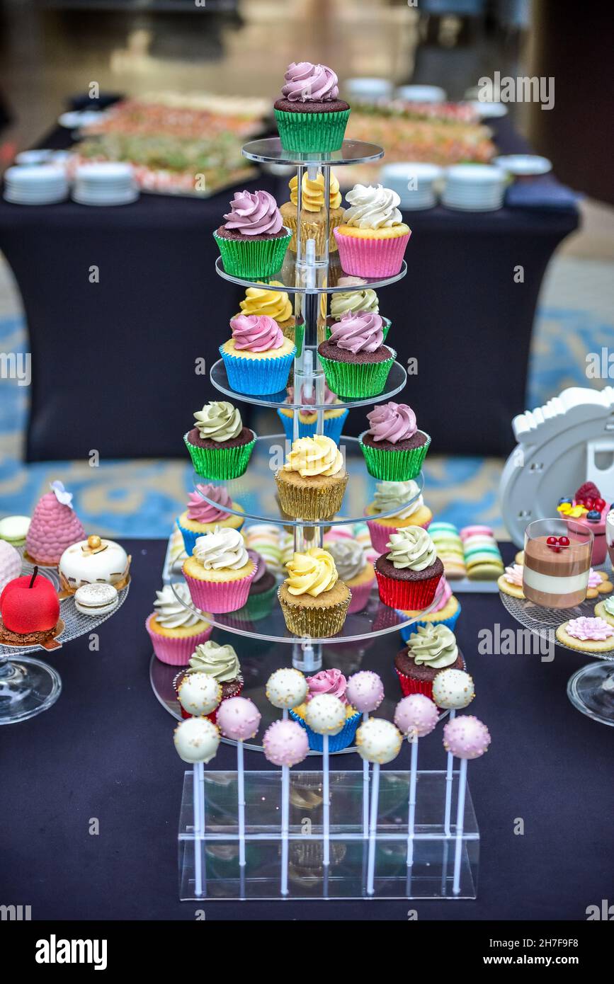 Sweet table setting with colorful cupcakes, lollipops and chocolate ...