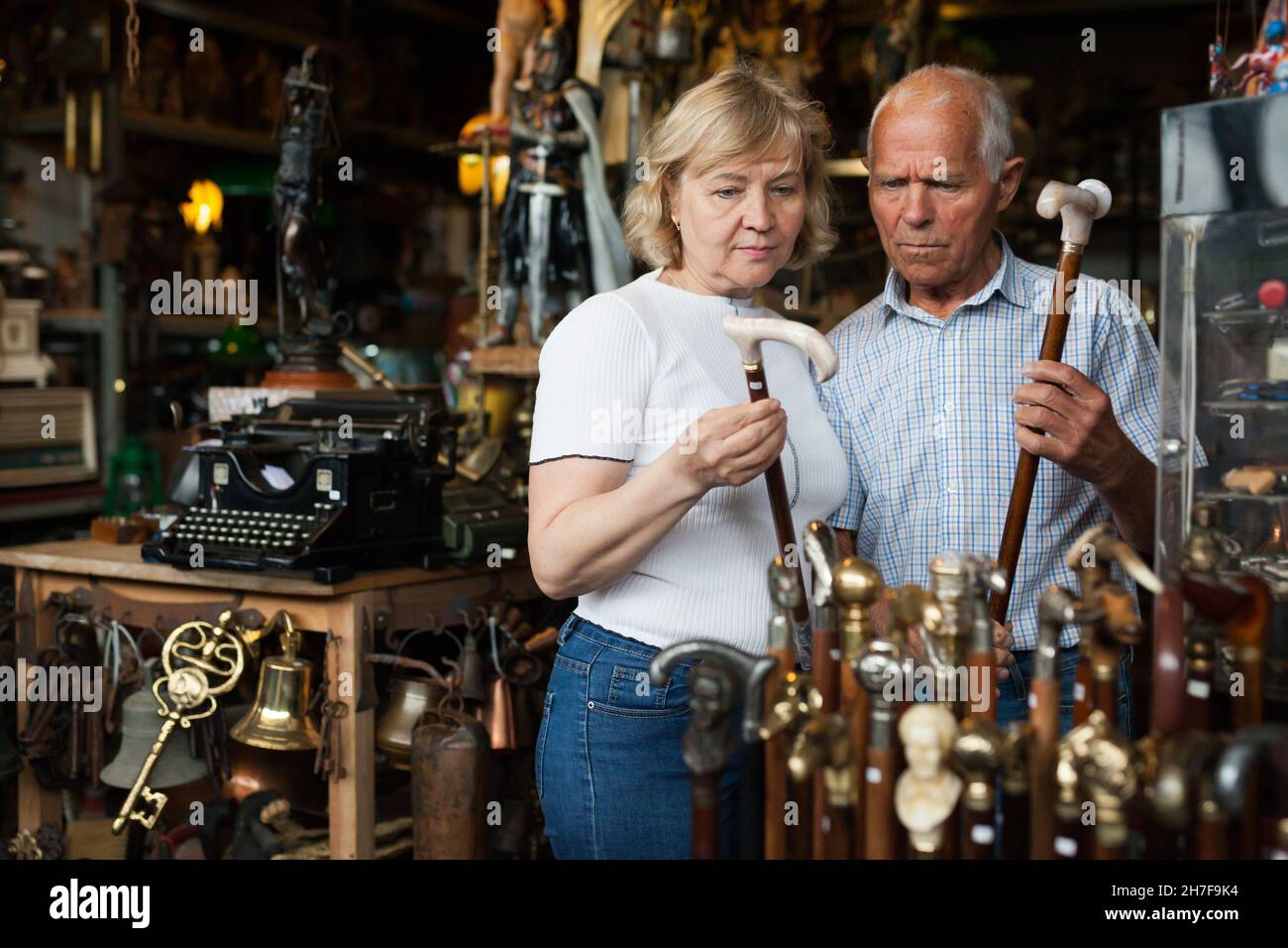 Elderly man and woman examine rare walking stick on flea market Stock ...