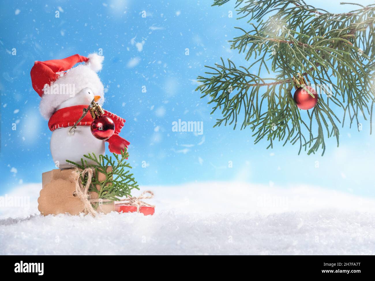 Happy snowman decorates the Christmas tree with Christmas ornament ...