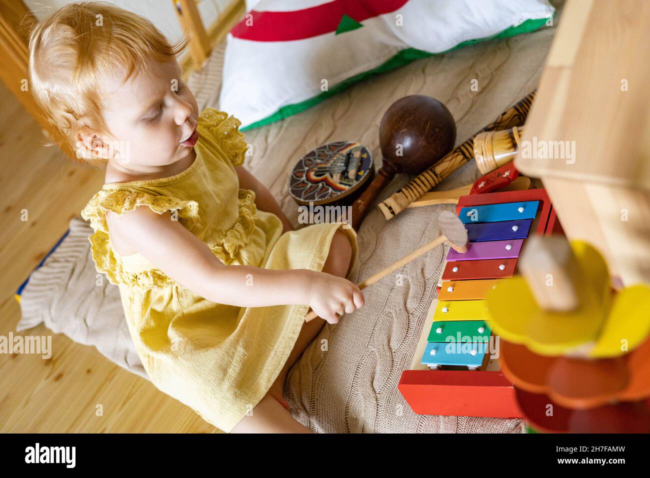 Cute baby girl playing wooden childish xylophone ecology toys Maria ...