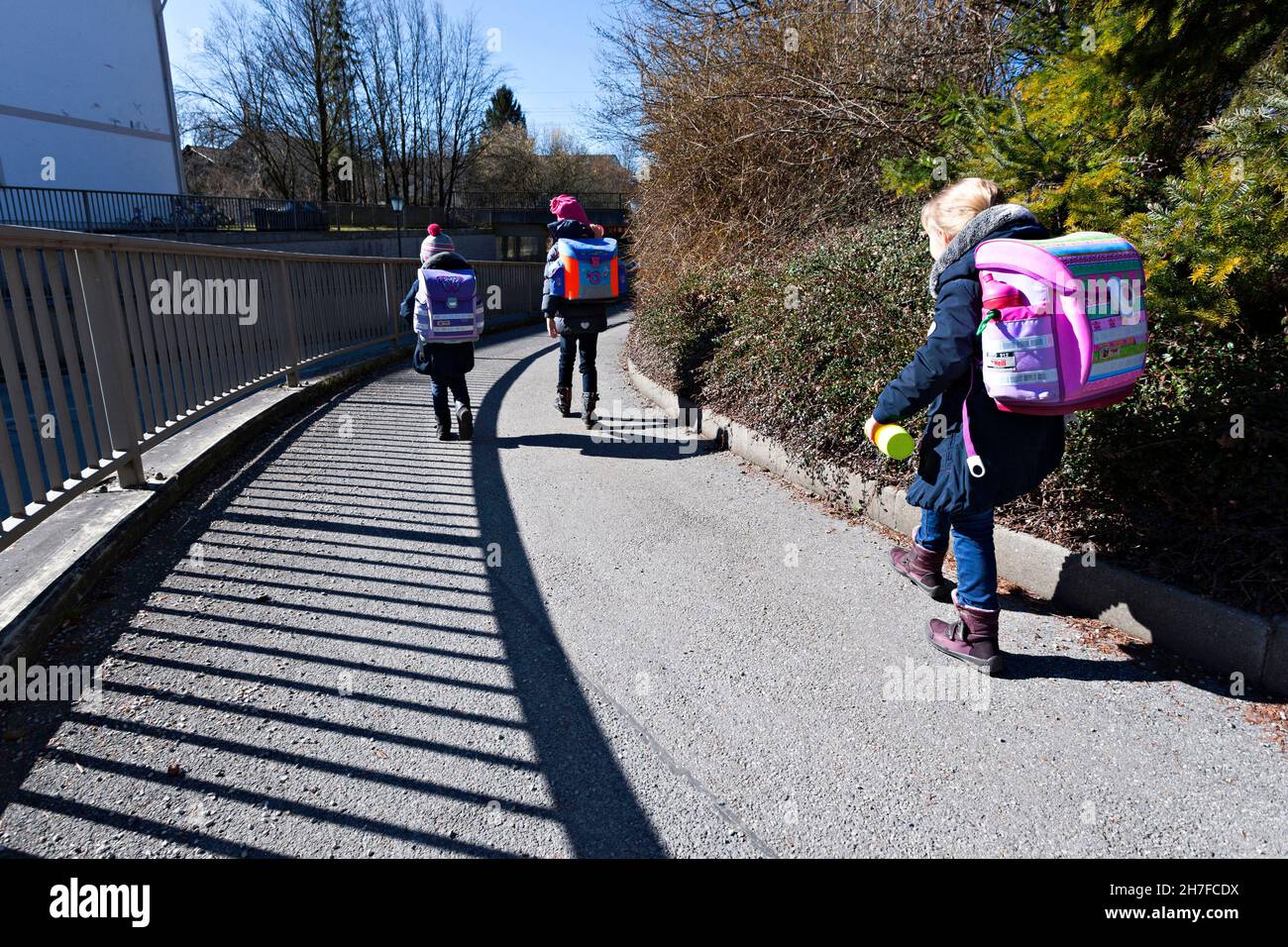 Young school children wearing backpacks, walking on footpath, Prien ...