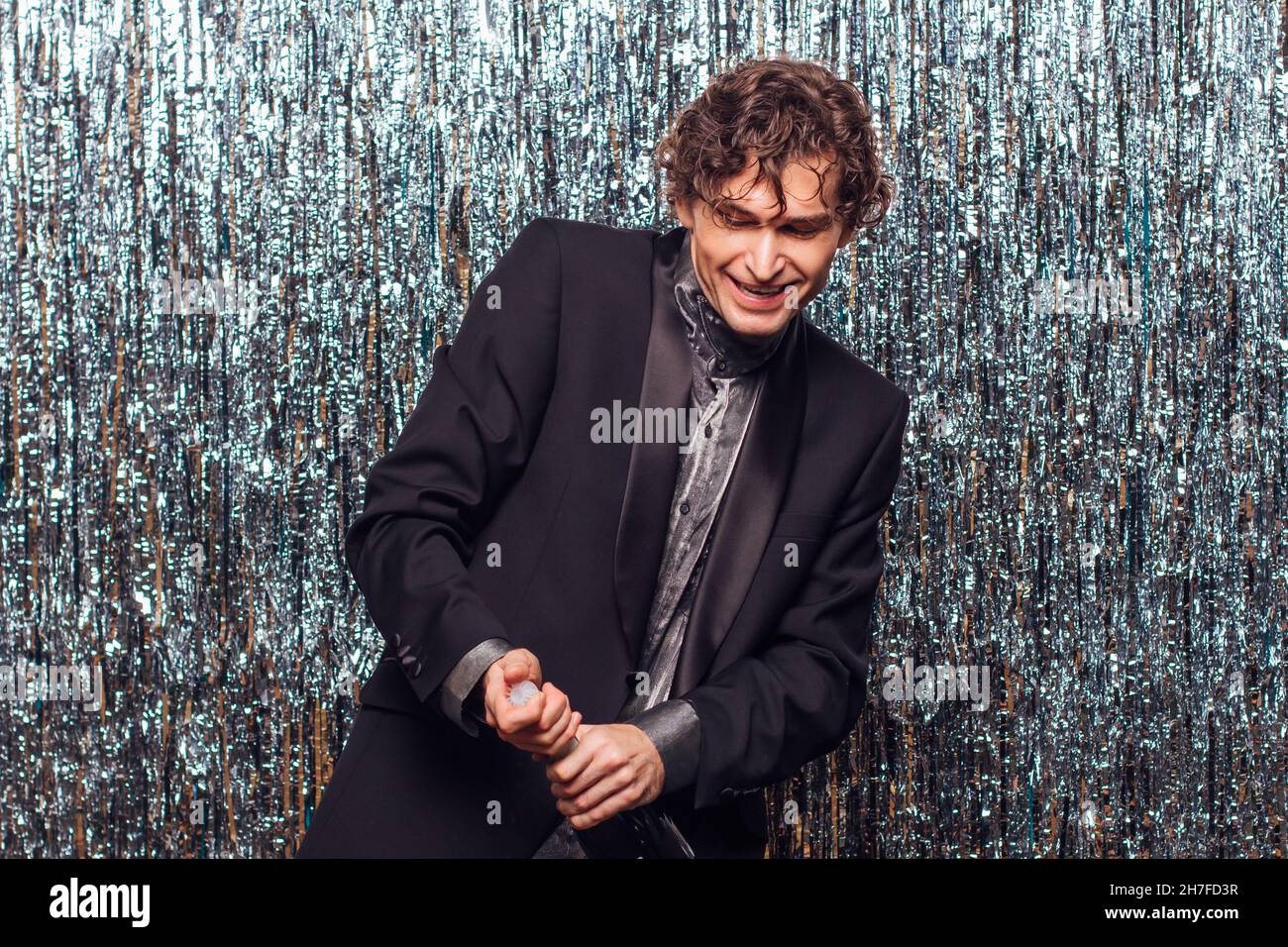 Happy tipsy man with bottle of champagne and wine glass at christmas or ...
