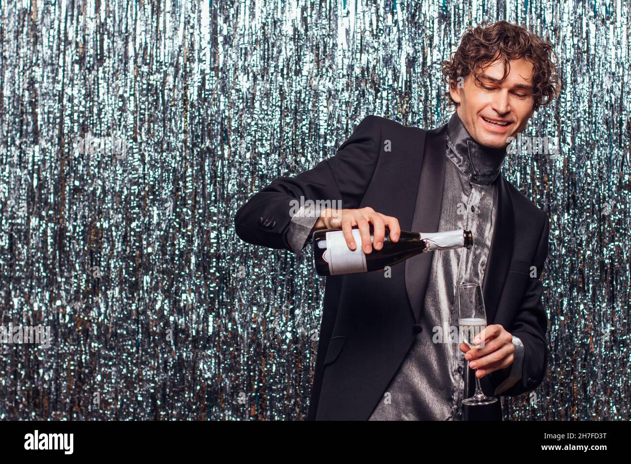 Happy tipsy man with bottle of champagne and wine glass at christmas or ...