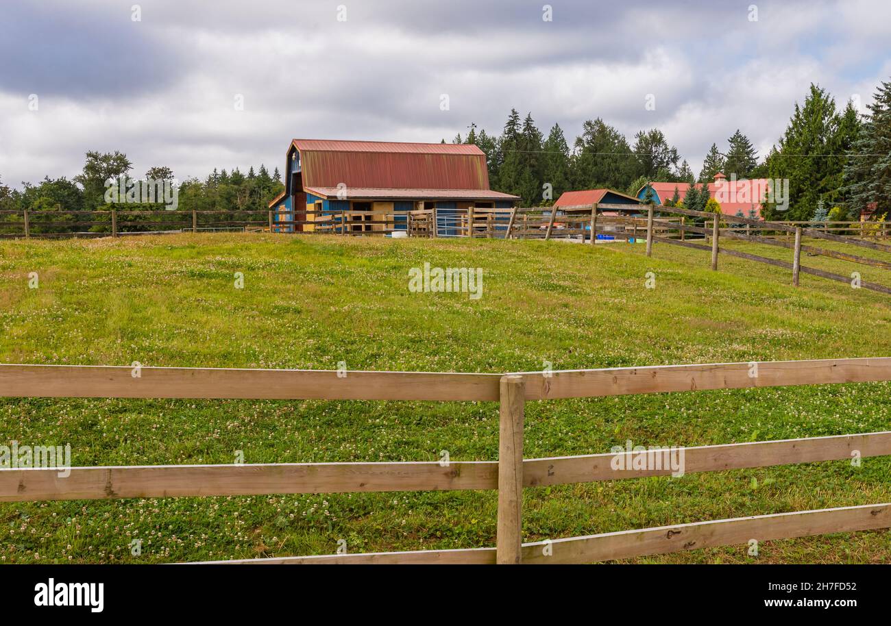 A wooden fence leading up to a big red barn. Rustic red barn in rural ...