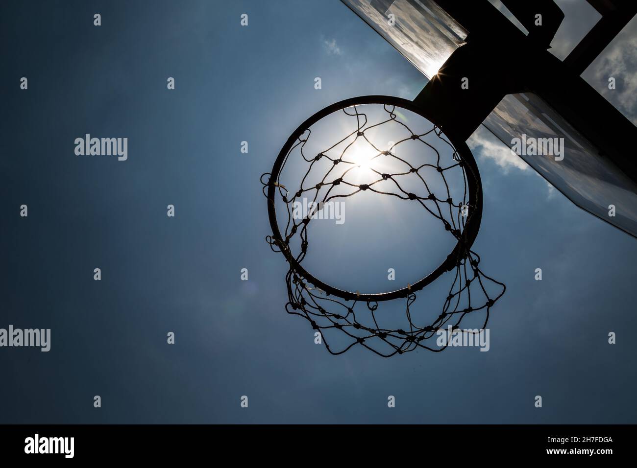 Siluate basketball hoop under the sun and blue sky background Stock ...