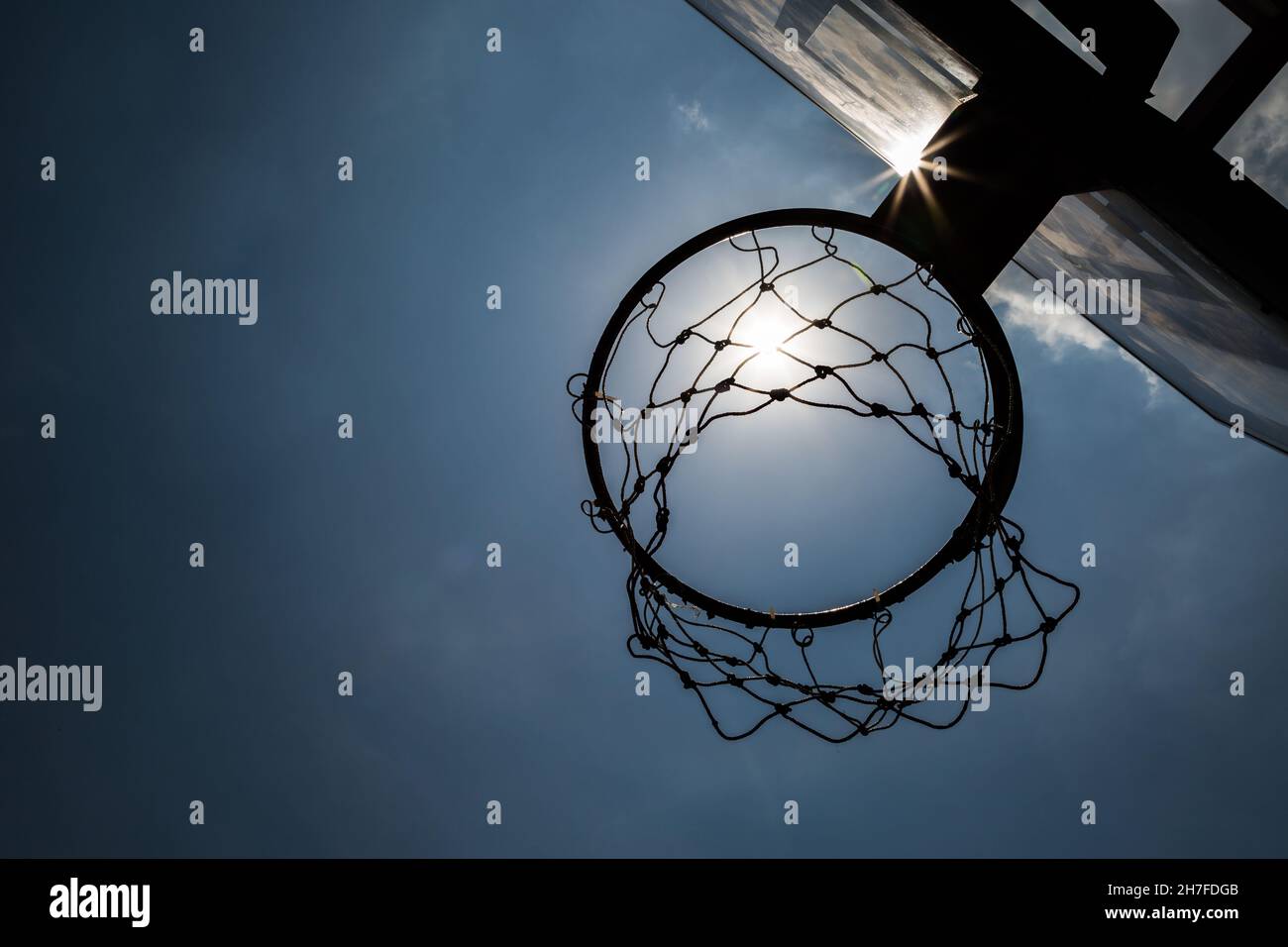 Siluate basketball hoop under the sun and blue sky background Stock ...