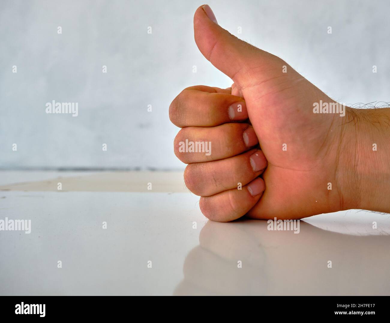 Hand and its shadow and reflection on the patterned wall of OKAY sign ...