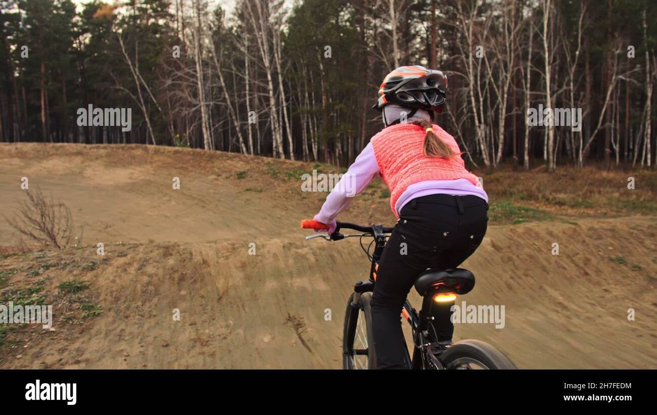 One caucasian children rides bike road track in dirt park. Girl riding ...