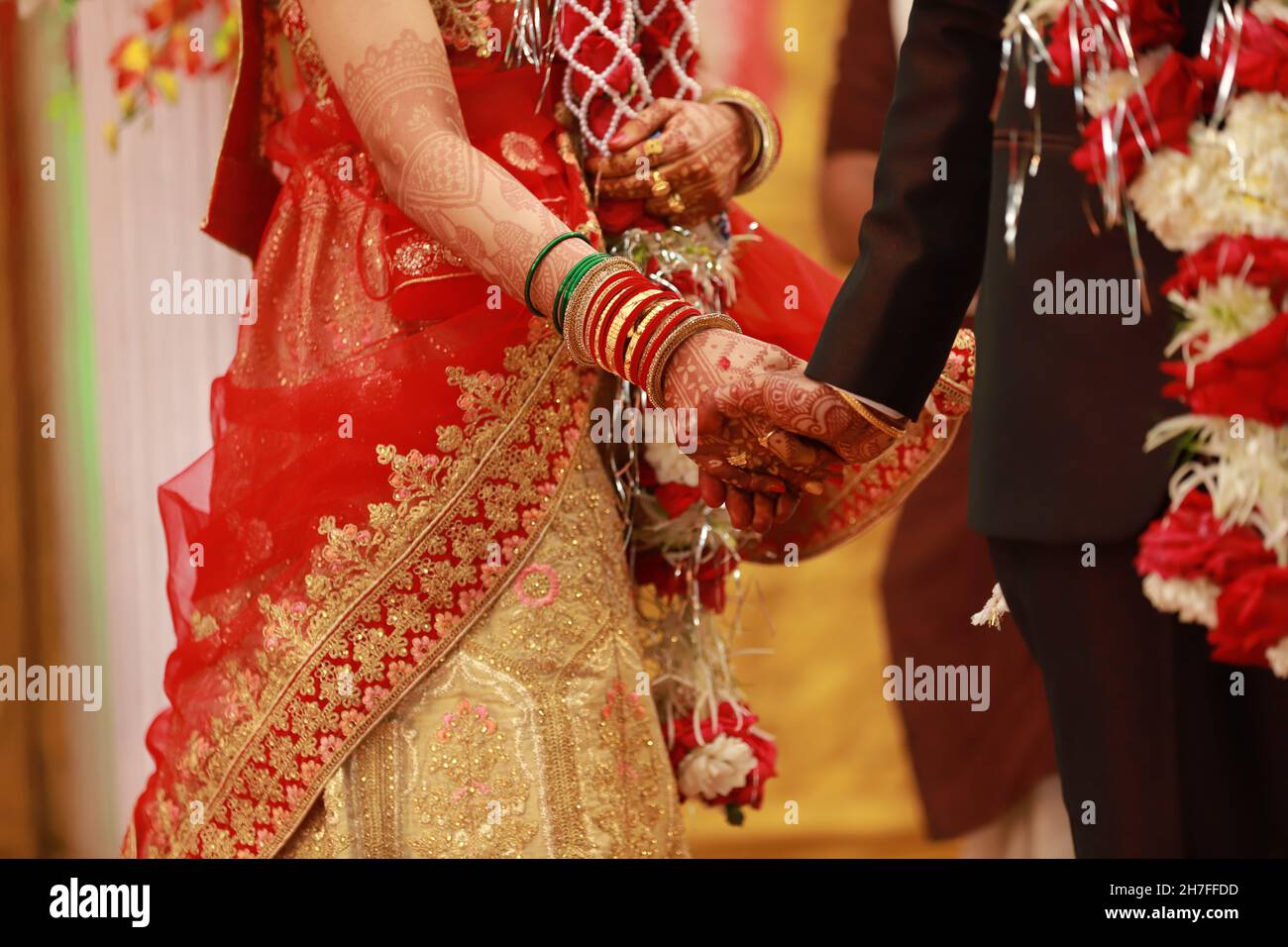Closeup of the groom and the bride holding hands during a traditional ...