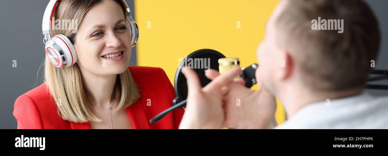 Attractive content radio host interviews a guest in studio closeup ...