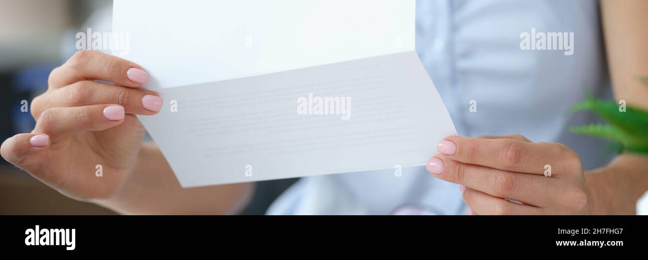 Woman reading letter while sitting at table with open envelope Stock ...