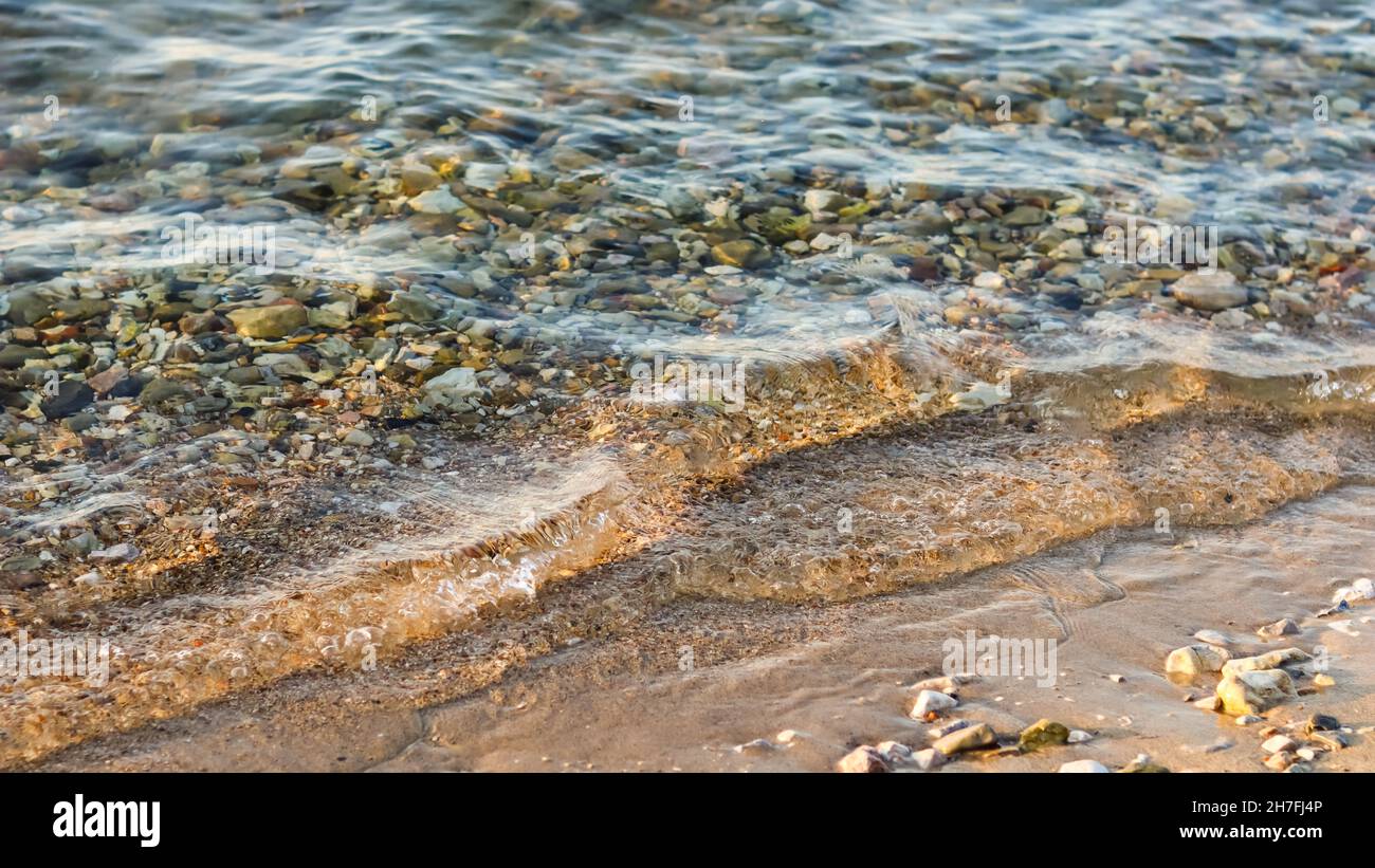 Background of sandy, stones and flowing waves on the sea beach. Summer ...