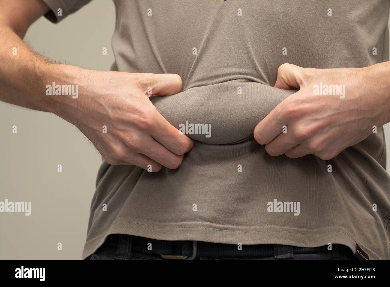 man holding the excess fat above his waist. Commonly referred to as a ...