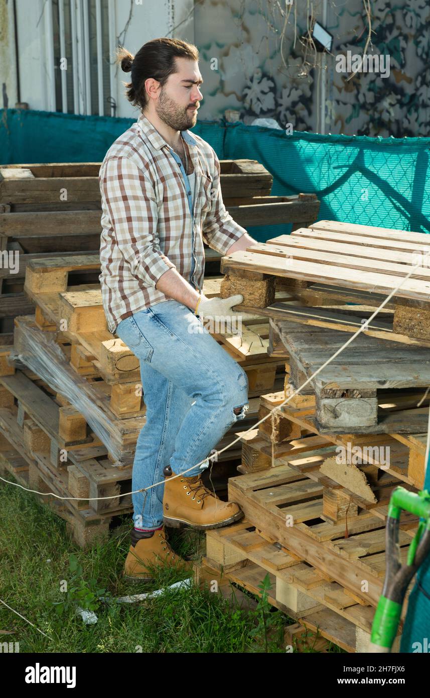 Man laying wooden pallets Stock Photo - Alamy