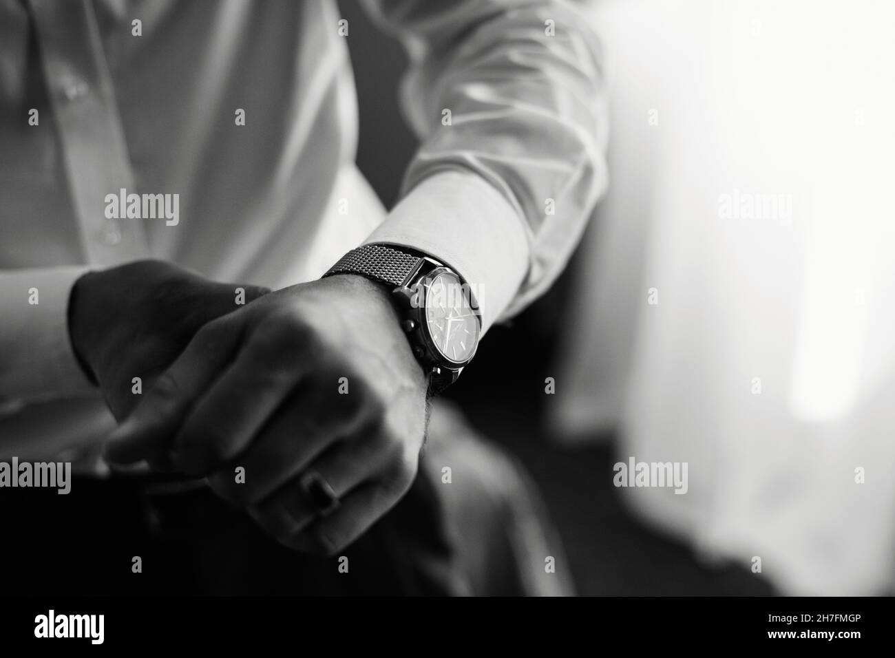 Man in white shirt wearing a silver watch Stock Photo - Alamy