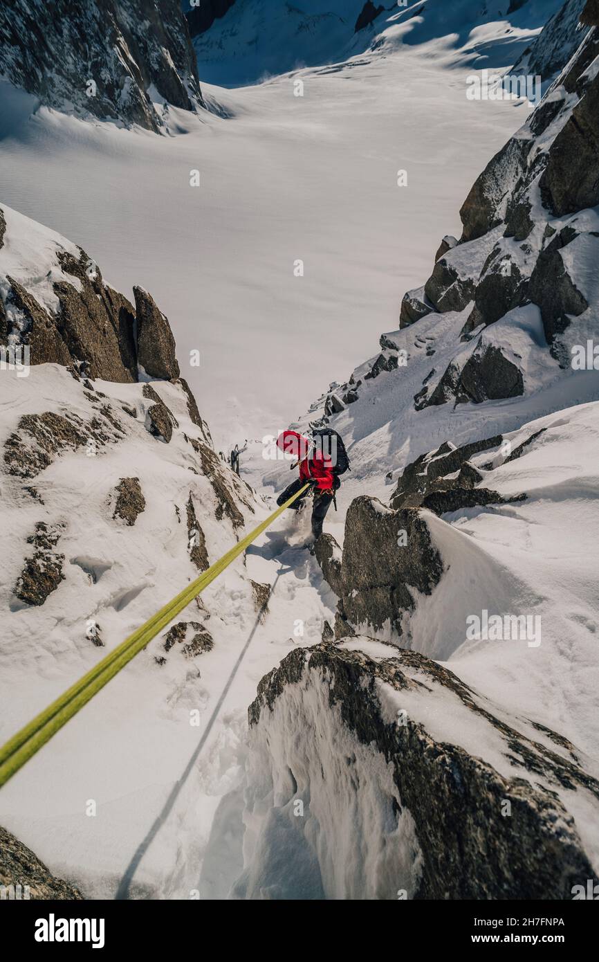 Climber rappeling down an alpine peak Stock Photo - Alamy