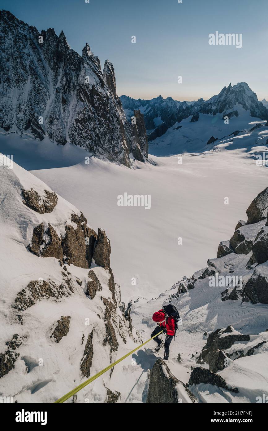 Climber rappeling down an alpine peak Stock Photo - Alamy