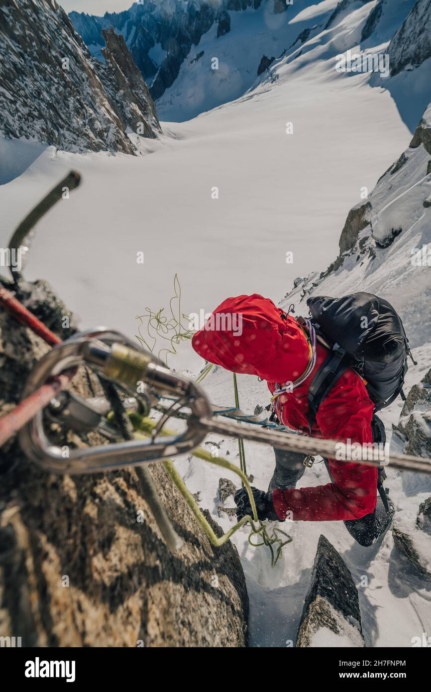 Climber rappeling down an alpine peak Stock Photo - Alamy