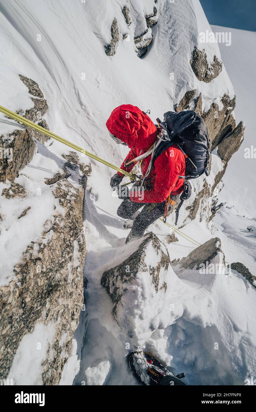 Climber rappeling down an alpine peak Stock Photo - Alamy