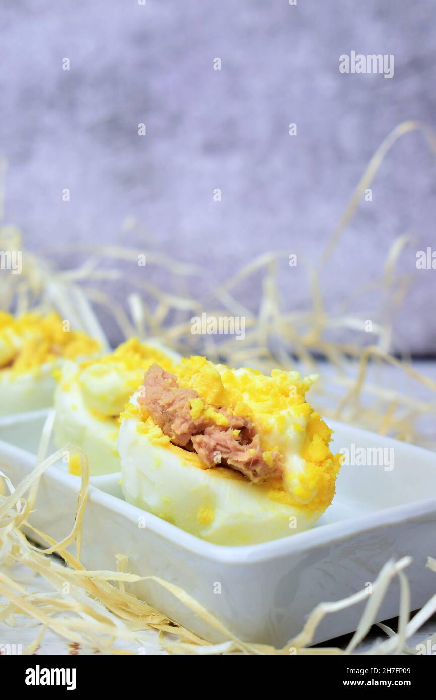 Close-up shot of eggs stuffed with tuna, mayonnaise layer and grated ...