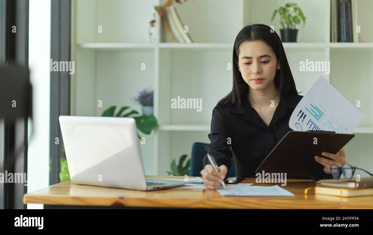 Asian young financial woman working with laptop computer and financial ...