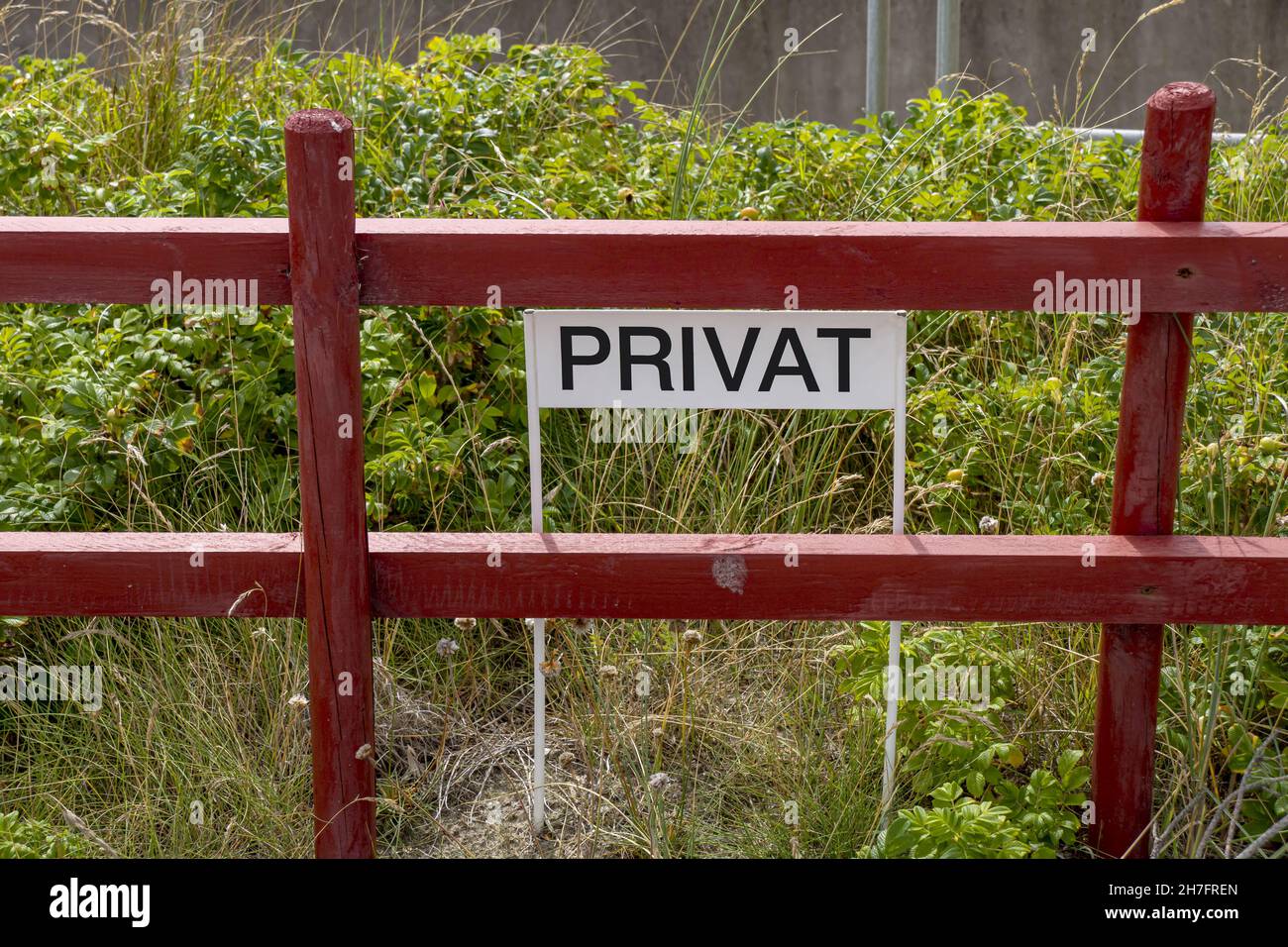 Red fence and green grass with privat sign Stock Photo - Alamy