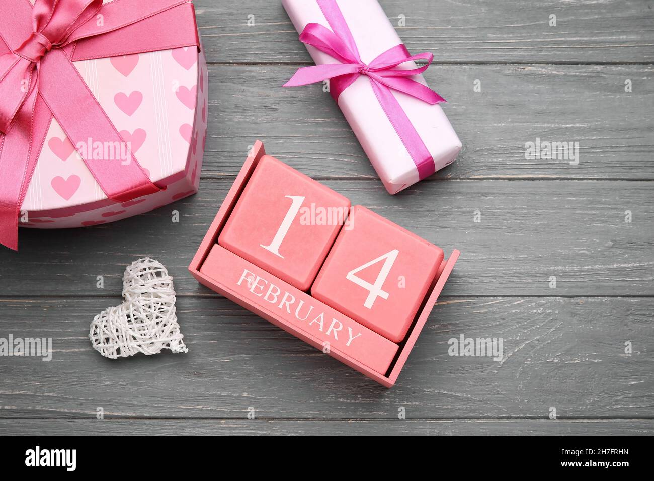 Calendar with date of Valentines Day and gift boxes on grey wooden ...