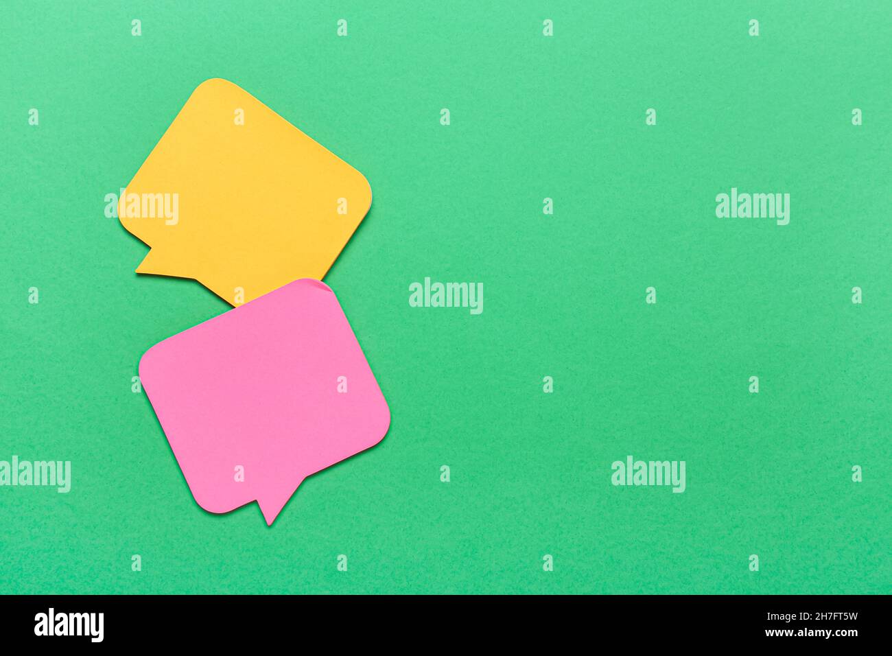 Sticky note papers in shape of speech bubbles on green background Stock ...