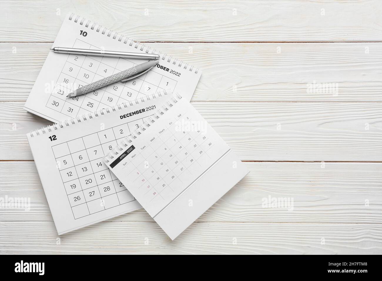 Different paper calendars for year 2022 on white wooden background ...