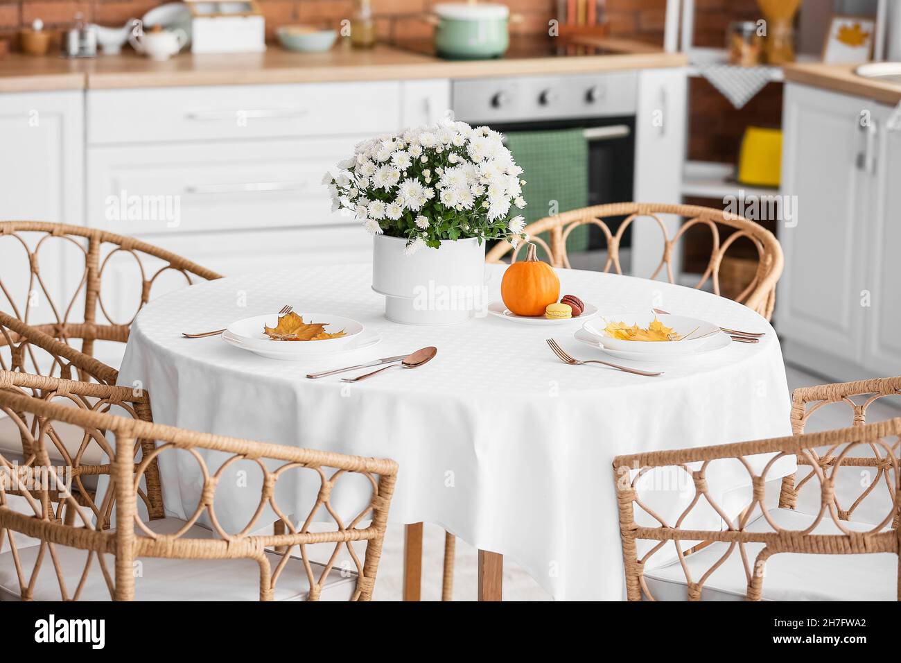 Dining table with beautiful Chrysanthemum flowers in interior of modern ...