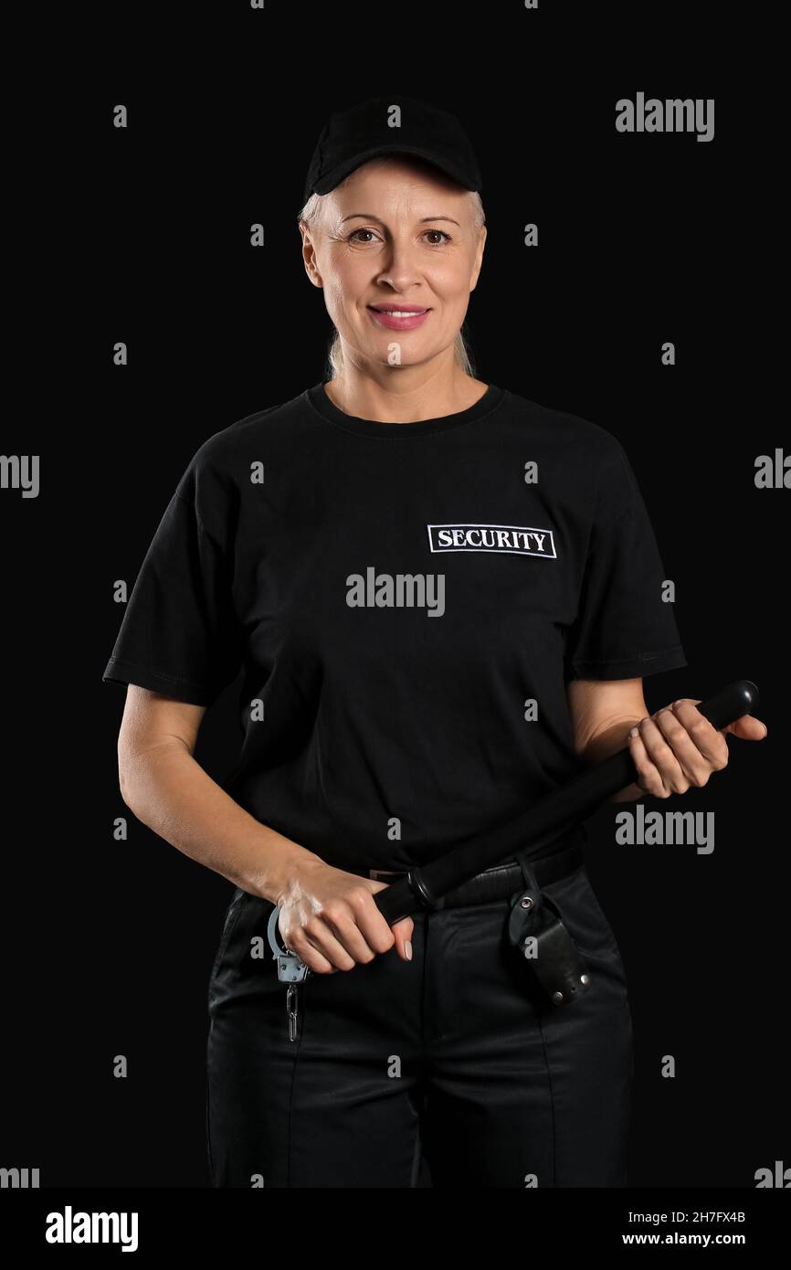 Female security guard with baton on dark background Stock Photo - Alamy