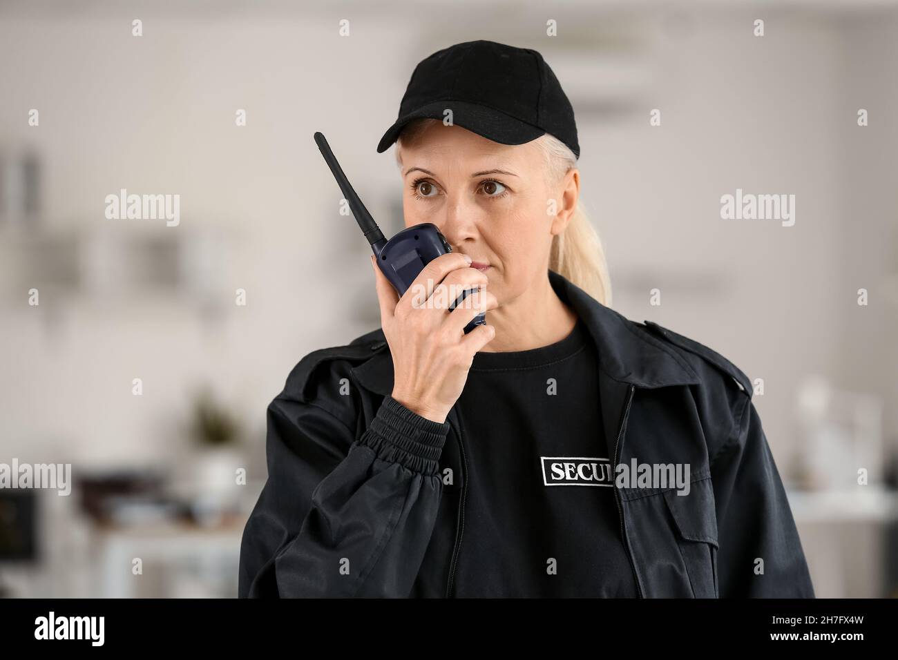 Female security guard with radio transmitter in office Stock Photo - Alamy