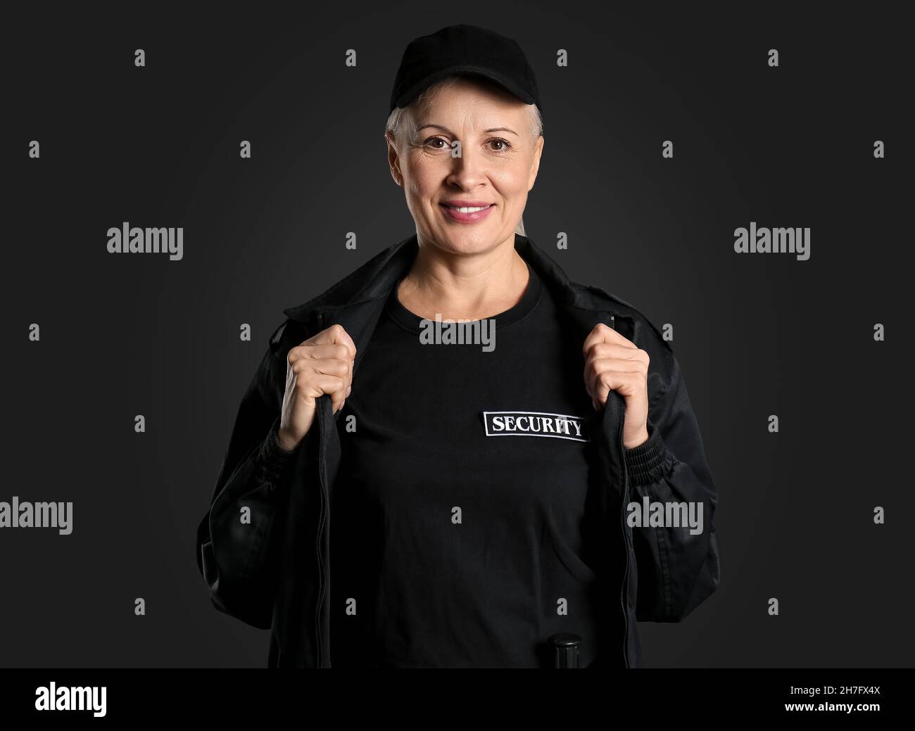 Female security guard on dark background Stock Photo - Alamy