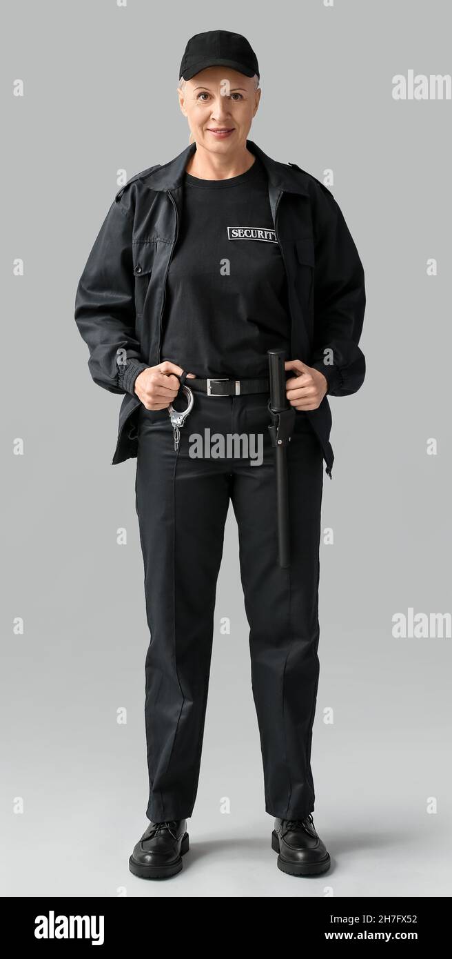 Female security guard on grey background Stock Photo - Alamy