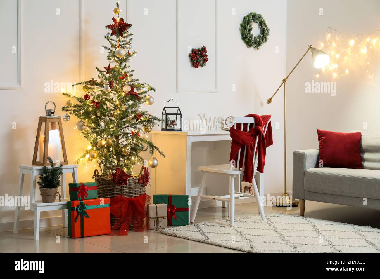 Interior of light room with modern workplace, Christmas tree and ...