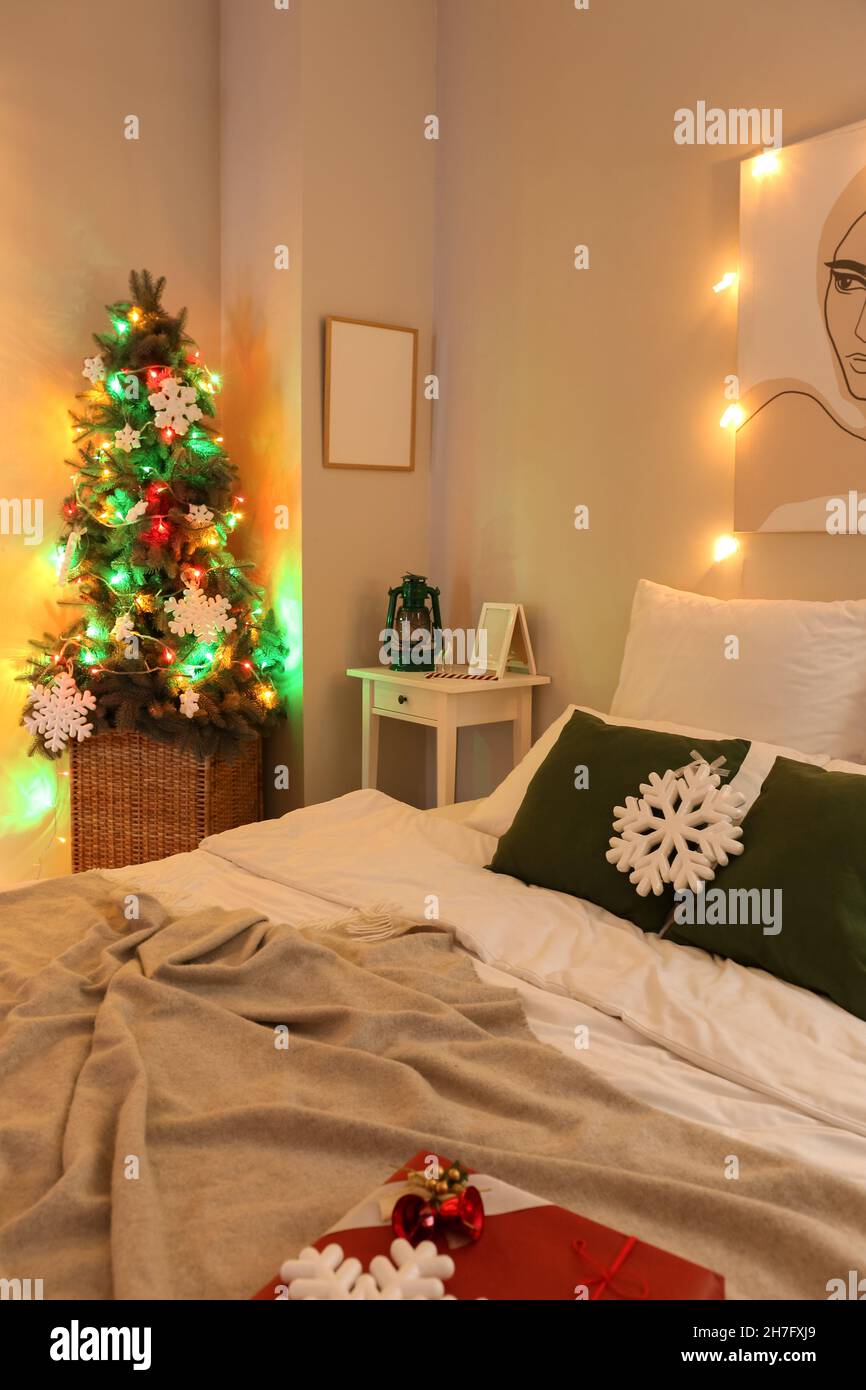 Interior of modern bedroom with Christmas tree and glowing lights Stock ...