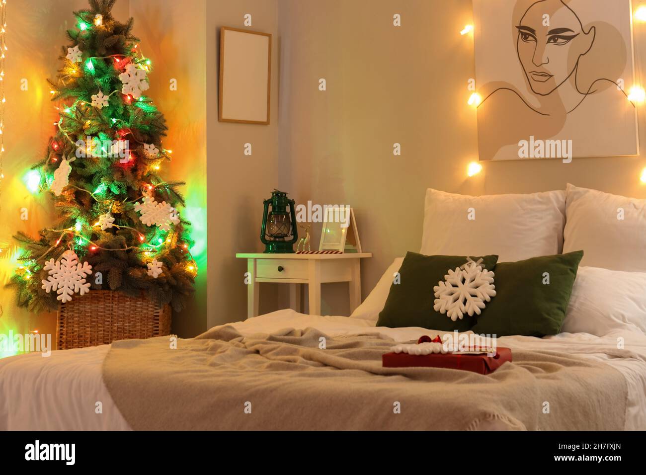 Interior of modern bedroom with Christmas tree and glowing lights Stock ...