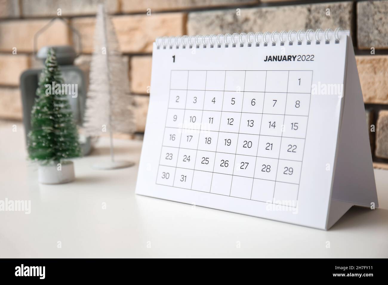 Paper calendar for January 2022 on shelf near brick wall, closeup Stock ...