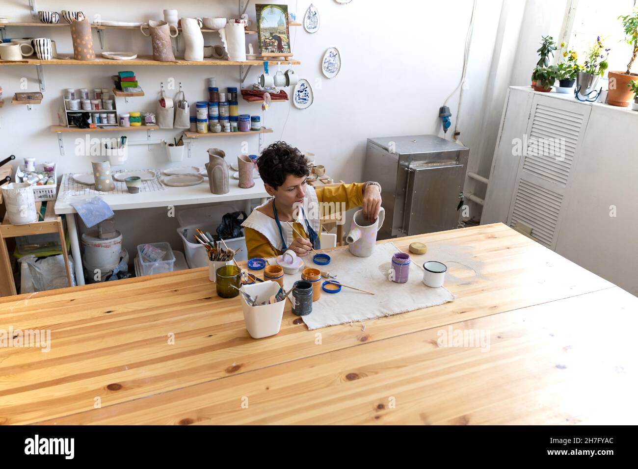 Process of decorating ceramics: woman ceramist hold paintbrush for ...