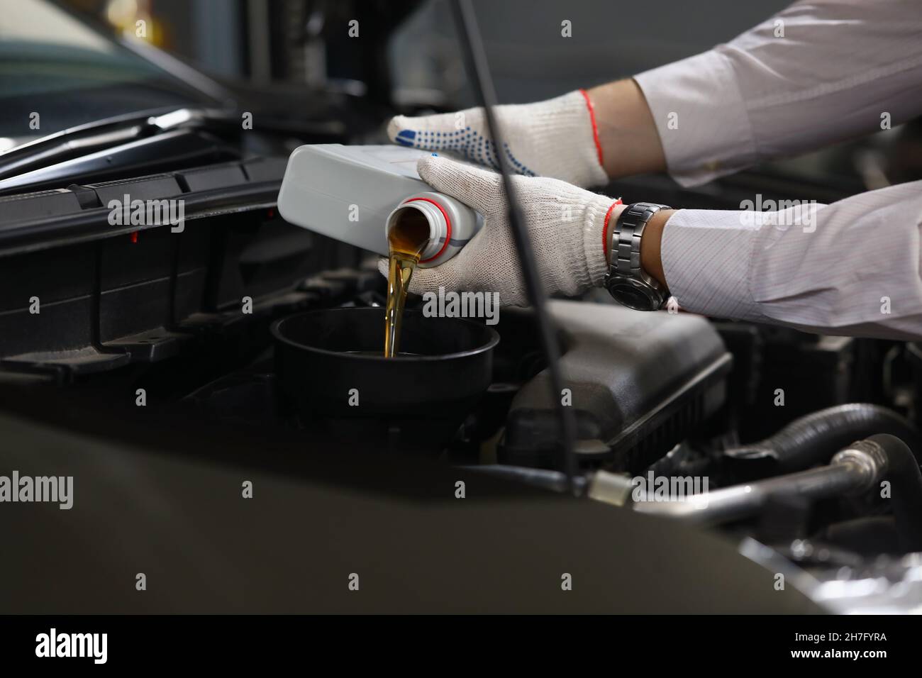 Refueling and pouring oil quality into engine motor car Stock Photo - Alamy
